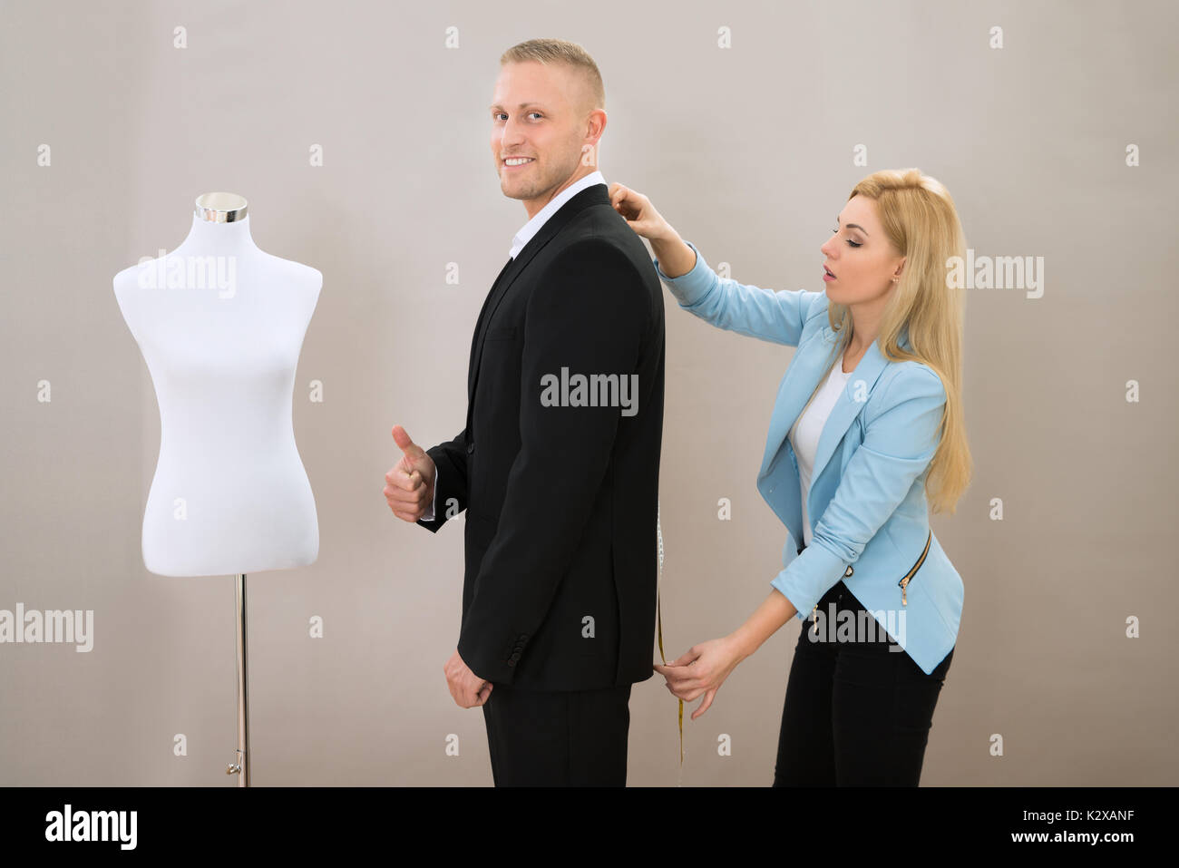 Female Tailor Taking Measurement Of Man Wearing Suit In Store Stock ...