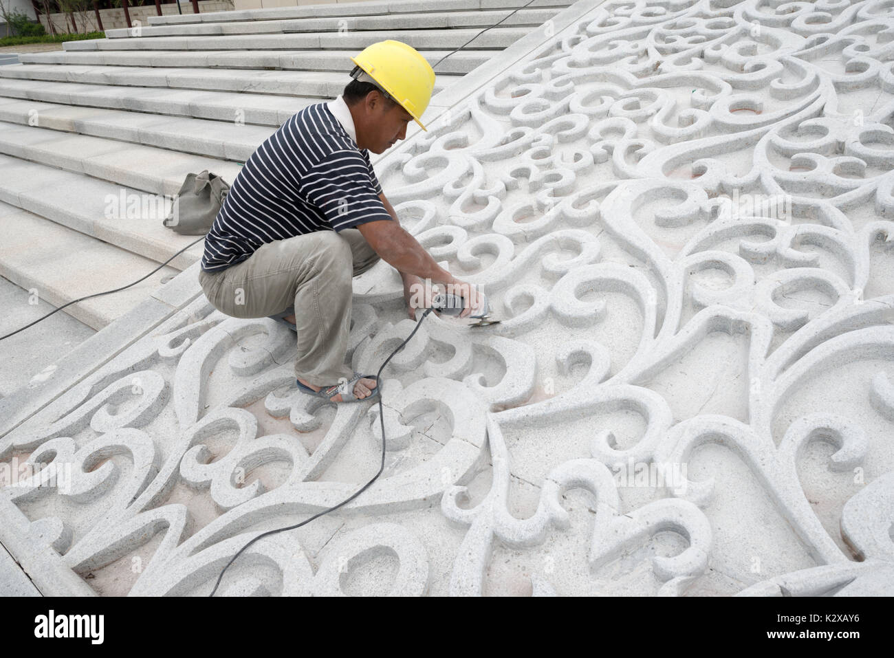 stone worker grinding and polishing traditional design stone carving ...