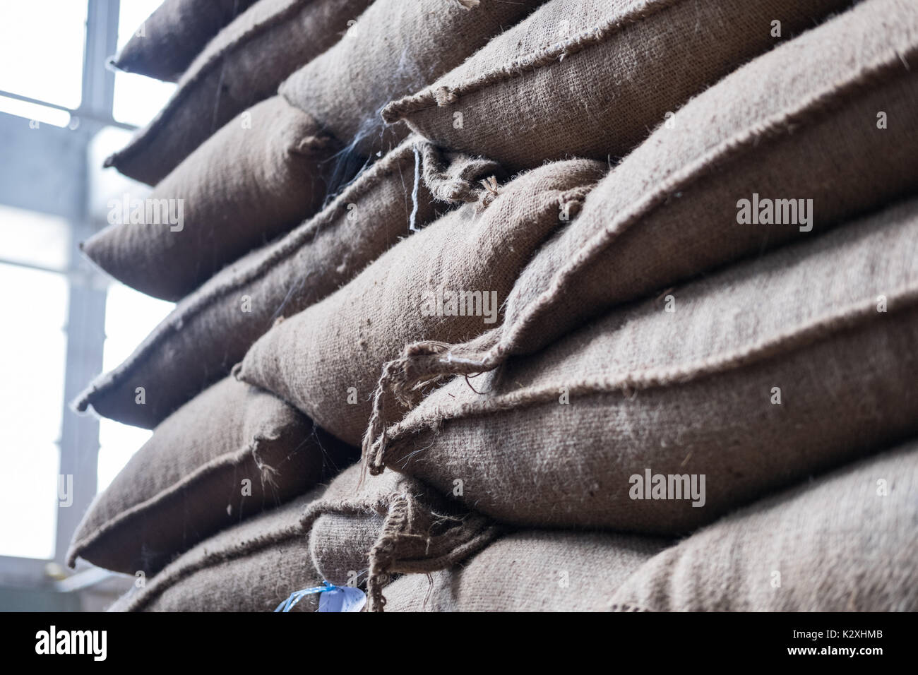 old hemp sacks containing coffee bean in warehouse. stacked sacks in ...