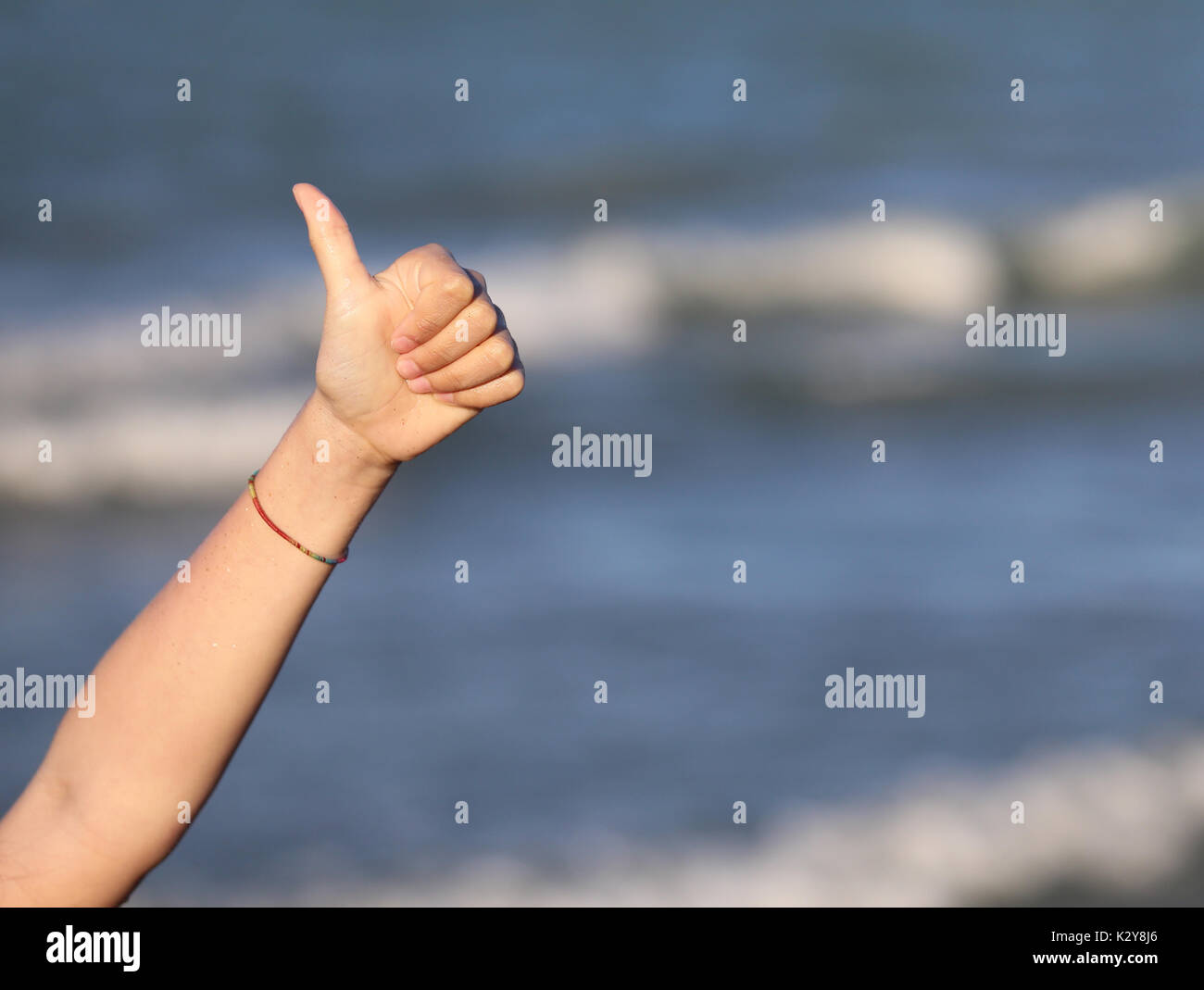 Thumbs up of baby's hand to say ok and the background of the sea Stock ...