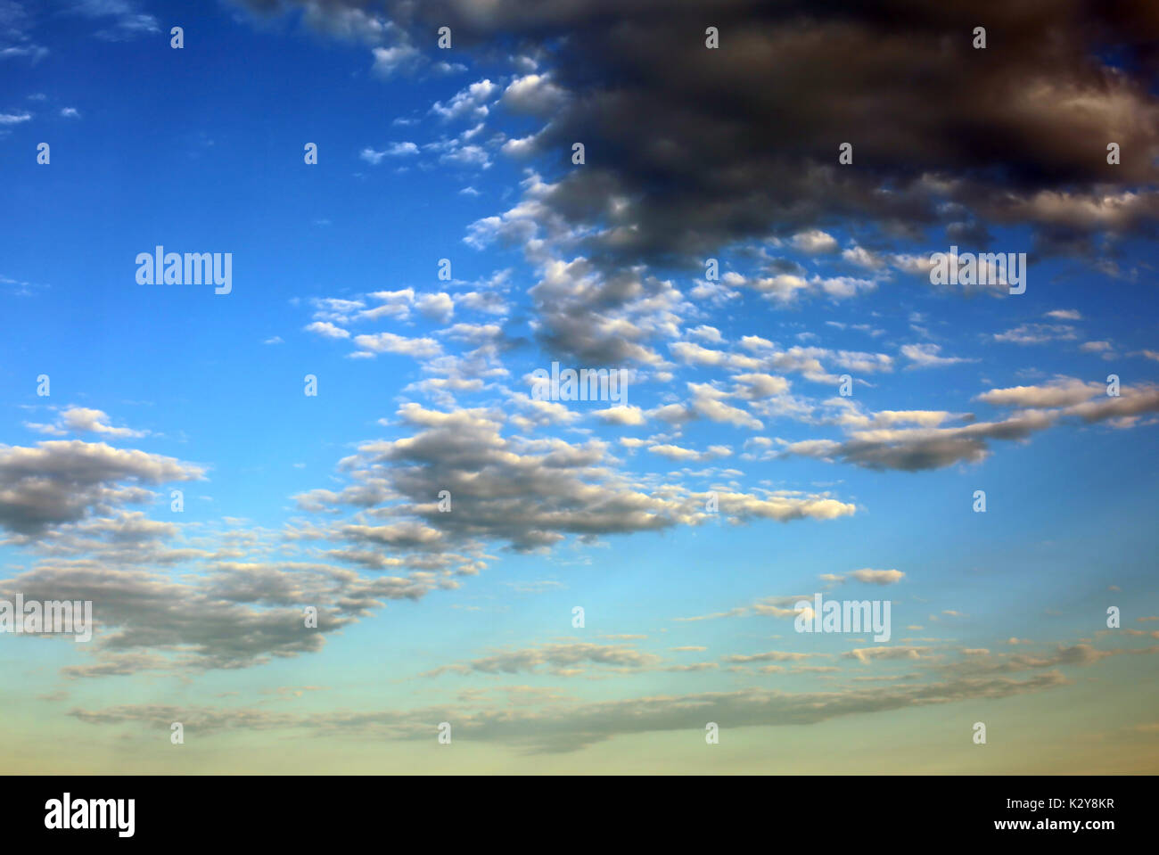 Simple blue sky background with dark clouds at sunset Stock Photo - Alamy