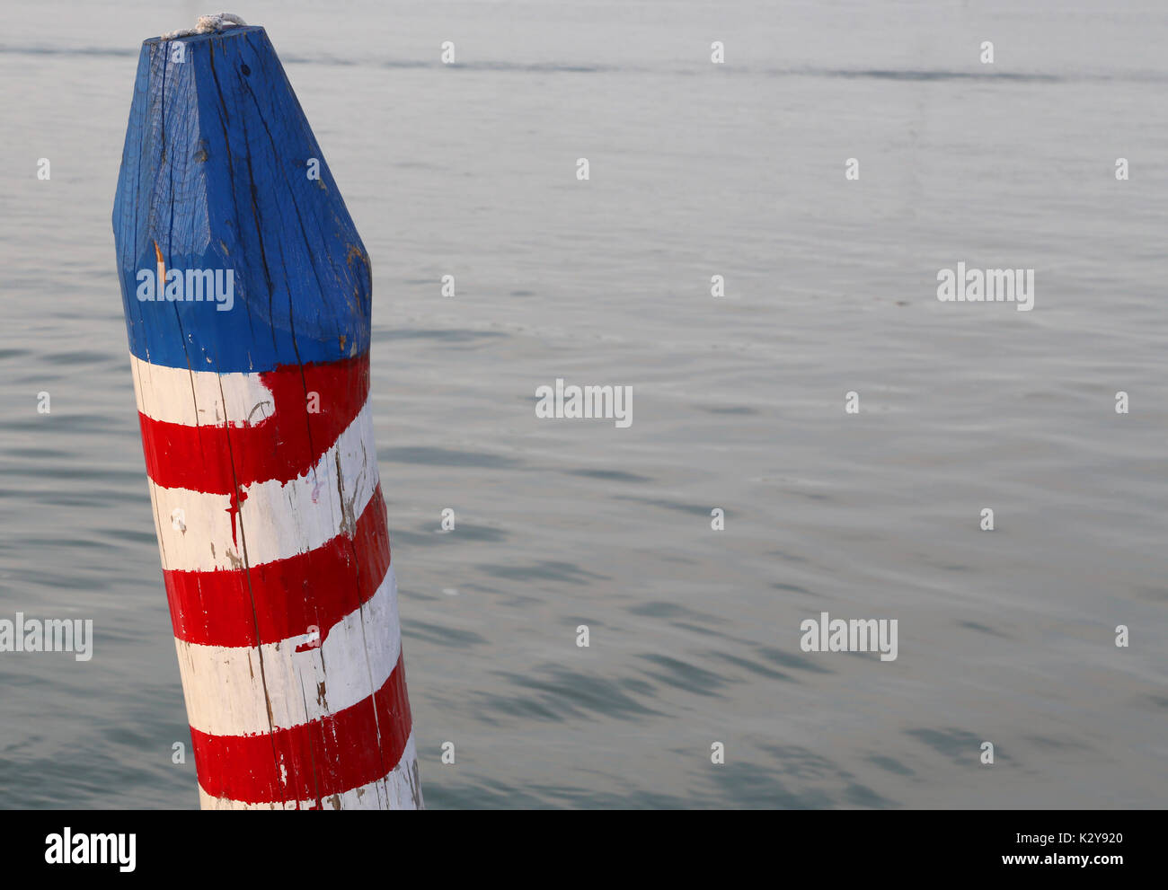 colored pole called Bricola in italian language to moor the boat near ...