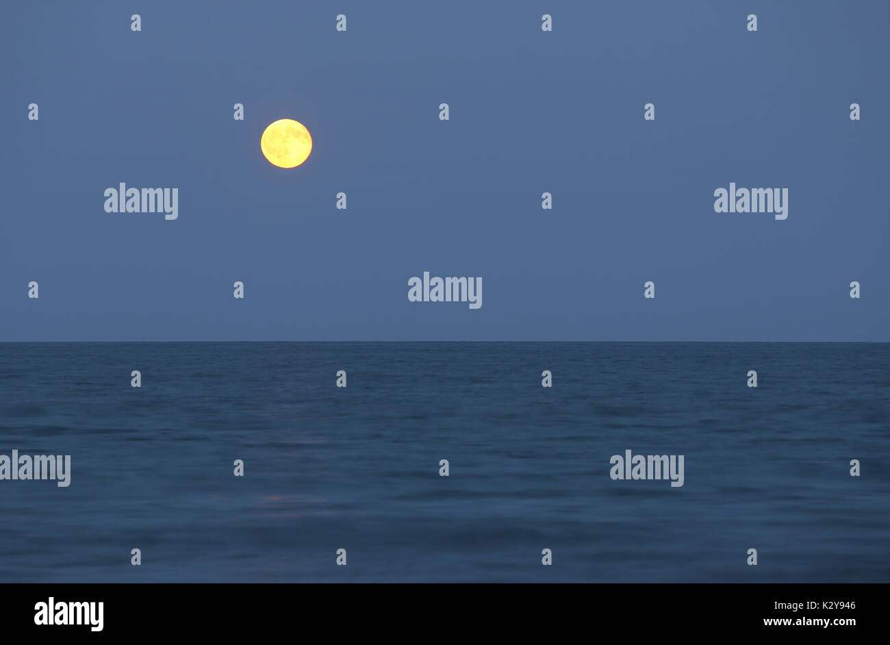 big full moon over the ocean in the night Stock Photo - Alamy