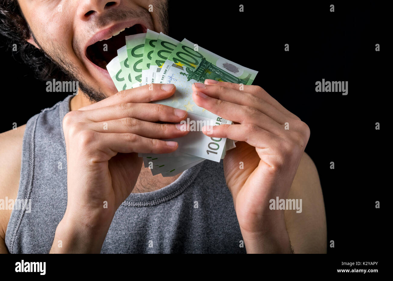 eating 100 euro money, hand holding one hundred euro cash isolated on a ...