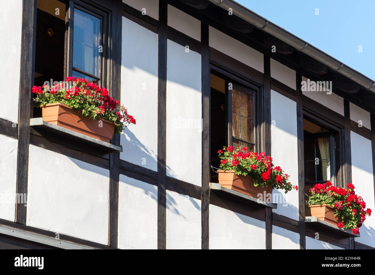 Half-timbered house with window shutters and colorful flowers Stock ...