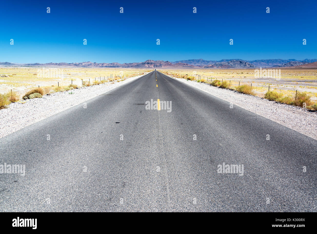Arid landscape and highway on the way to Death Valley in California ...
