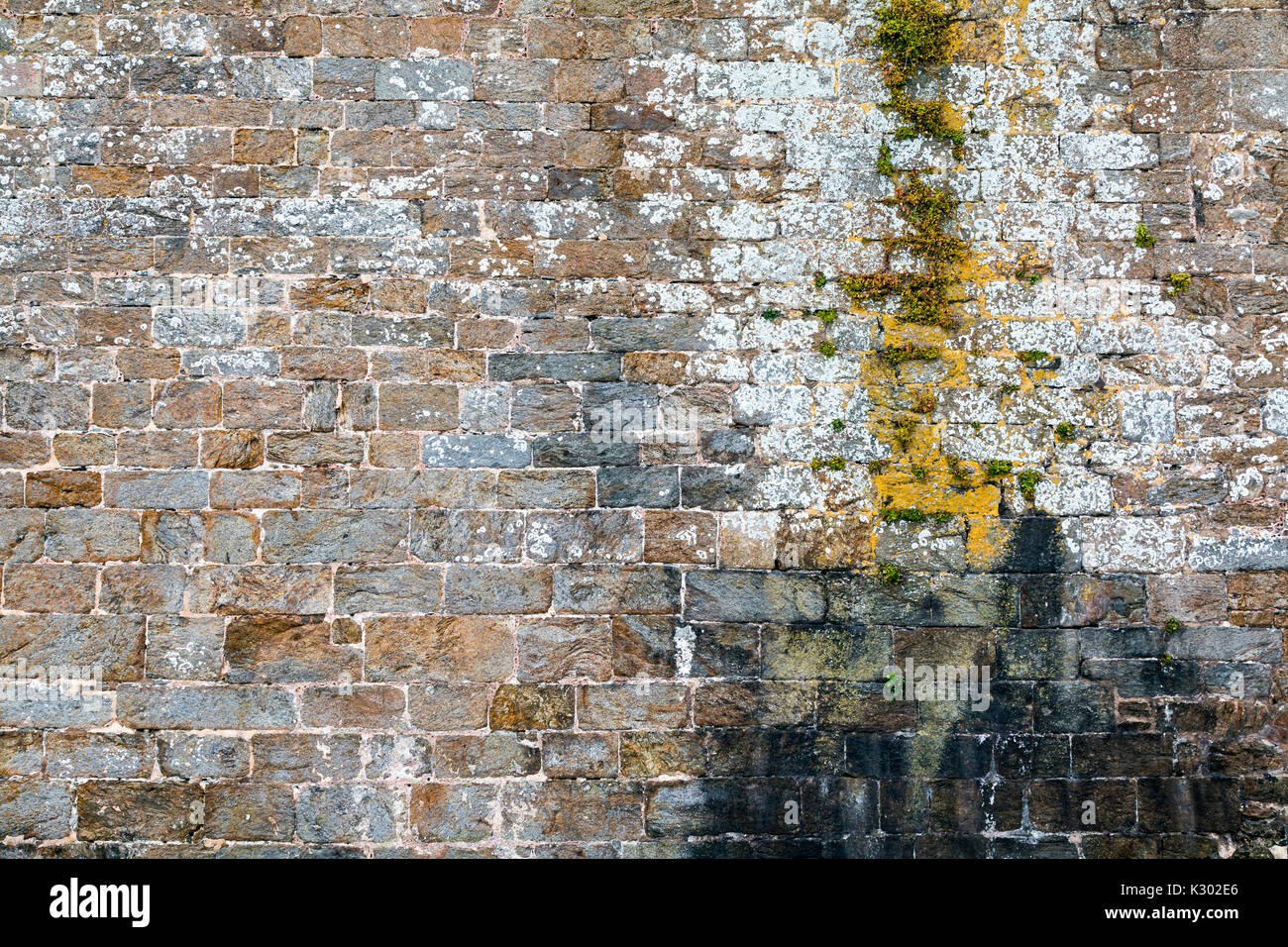 Stone wall texture with decay from long term water leak and moss ...
