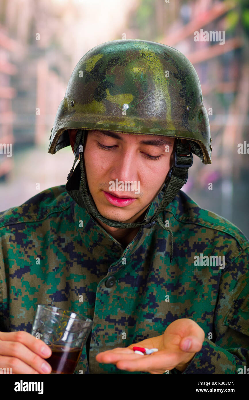 Handsome young soldier wearing uniform suffering from stress post-war ...