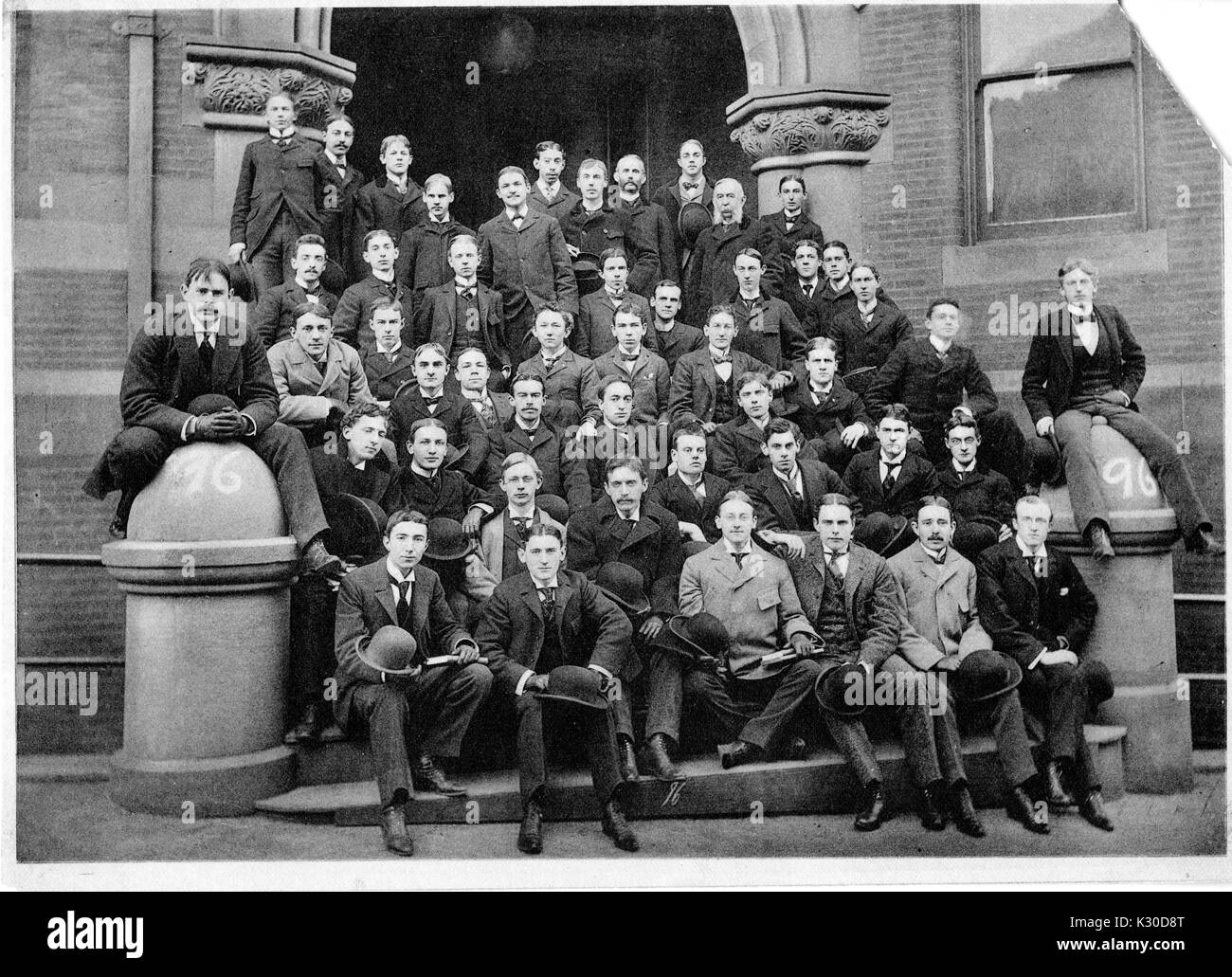 Class of 1896 wearing suits seated on the steps of a brick building at ...