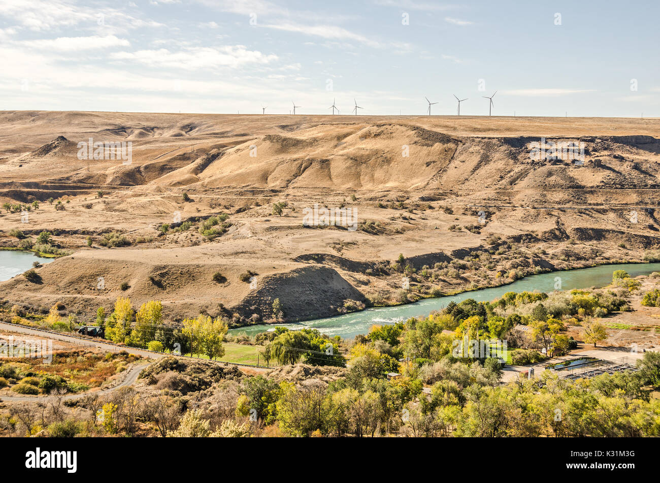 Wind turbines dot the bench above the valley where the river flows ...