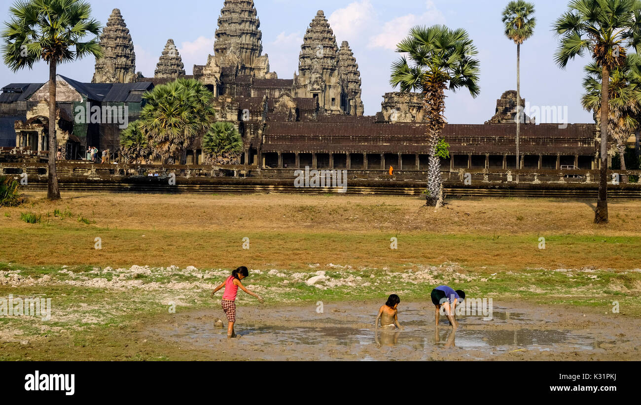 Cambodian children play in pools of water in front of Angkor Wat ...