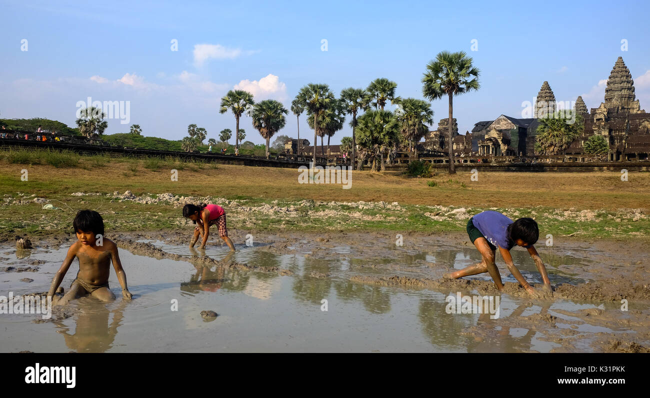Cambodian children play in pools of water in front of Angkor Wat ...