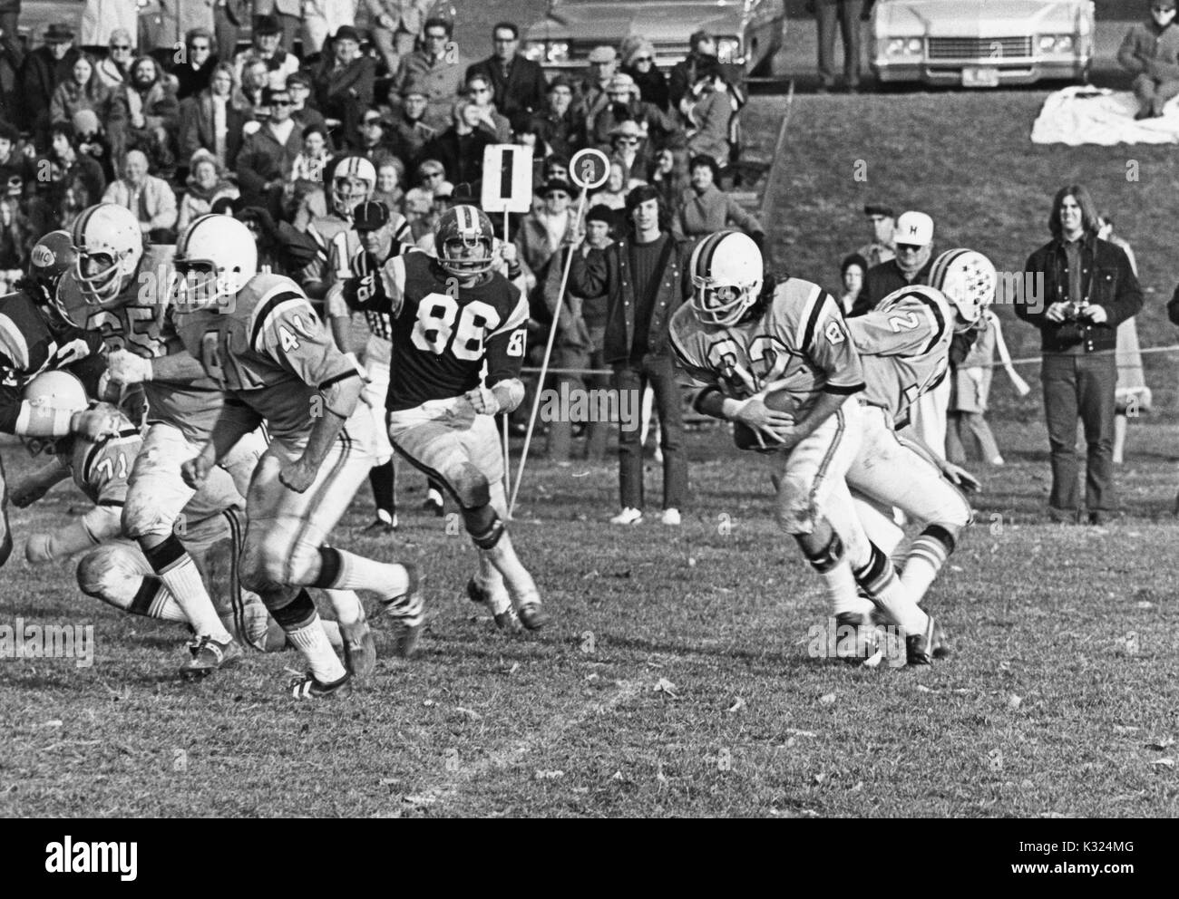 Spectators in the background watch a college football game between ...