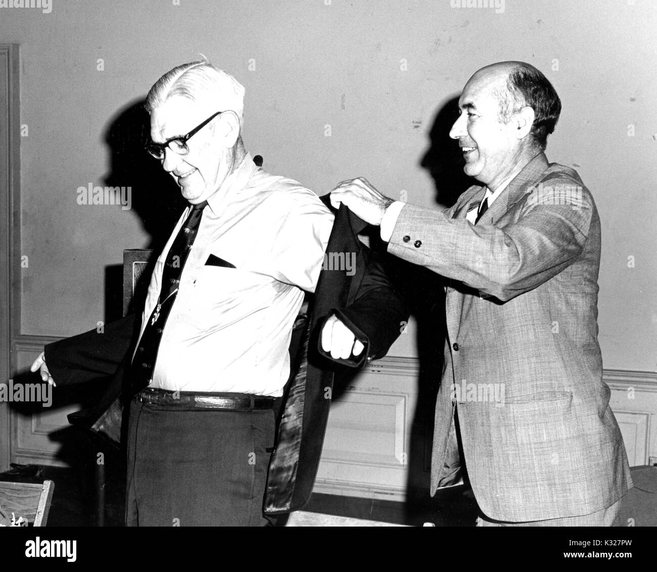 An unidentified man helps Robert Hall Roy, Dean of Johns Hopkins ...