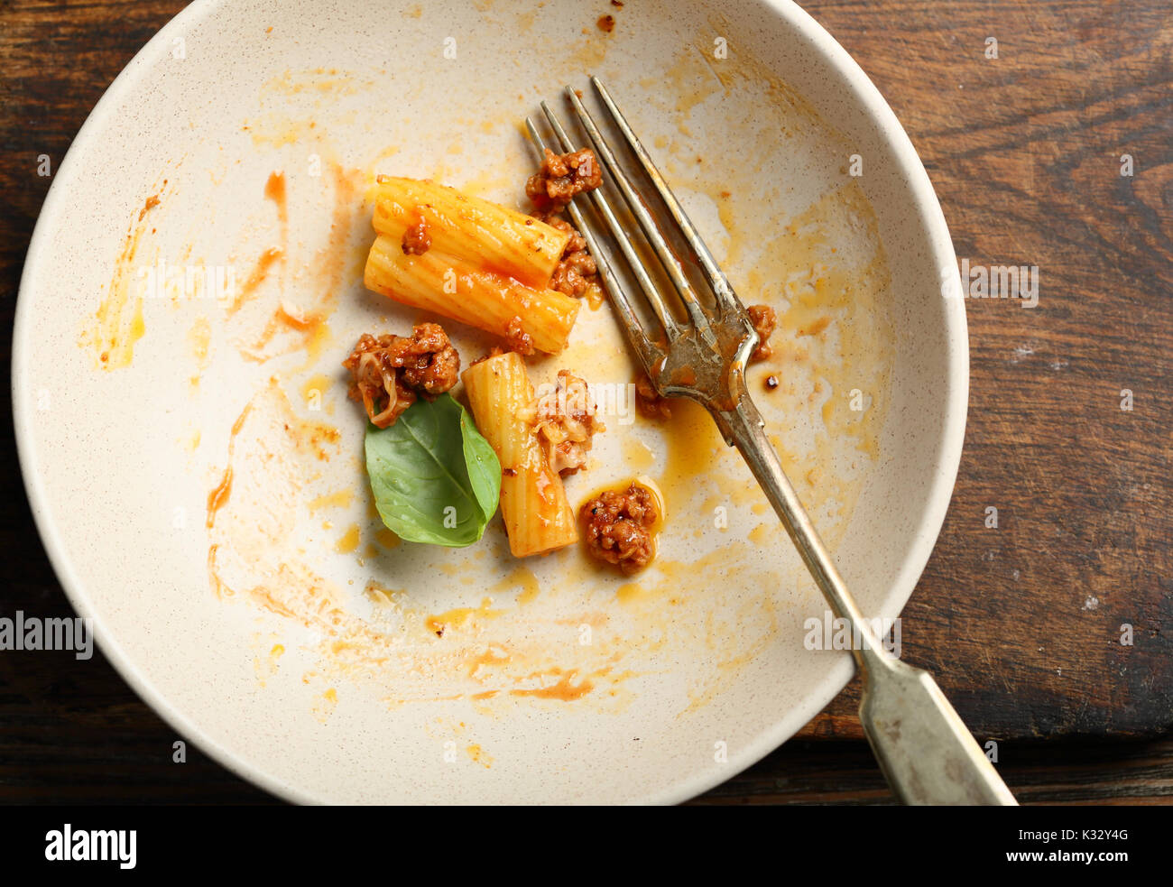 Empty plate after Pasta with basil leaves , plate Stock Photo - Alamy