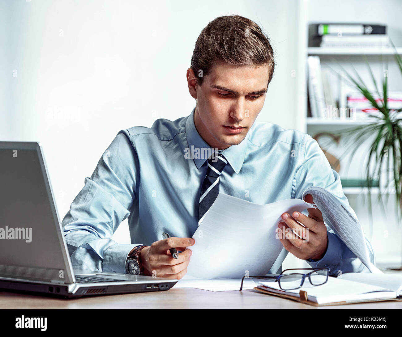 Serious businessman sitting at his desk reading a documents. Photo of ...