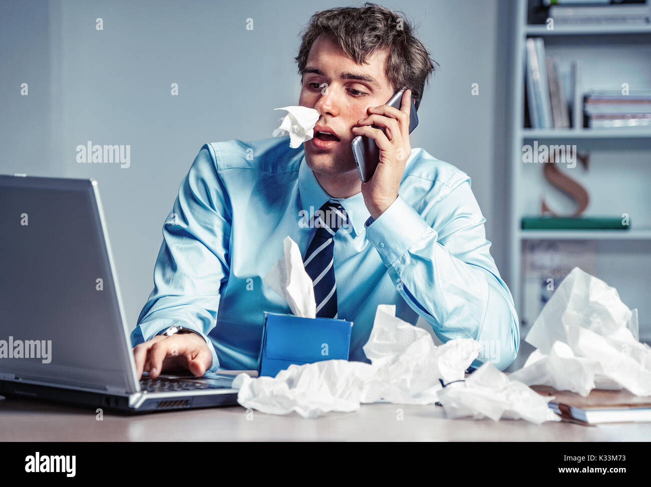 Sick worker with paper tissues on the desk, talking on the phone. Photo ...