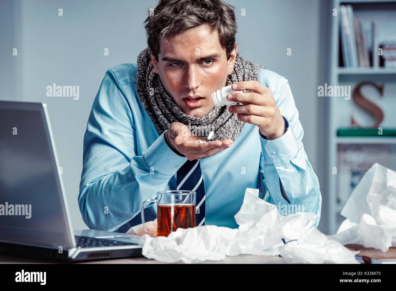 Sick employee takes pills for flu in the office. Photo of young man ...