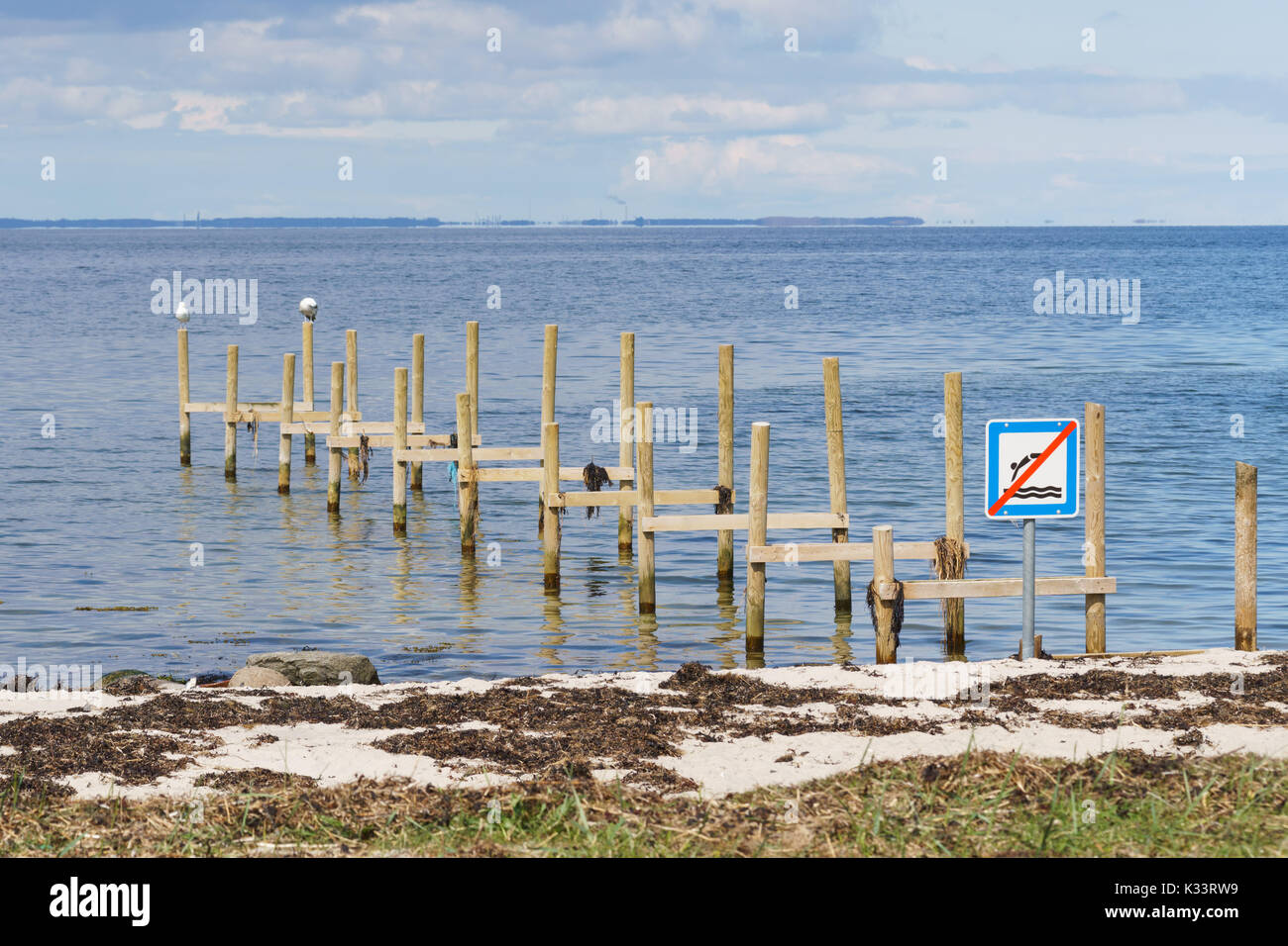 Remains of an old wooden pier in Langeland, Denmark with a sign saying ...