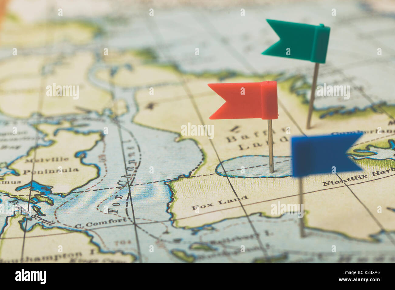 Flag shaped push pin in a vintage travel map. travel destination ...