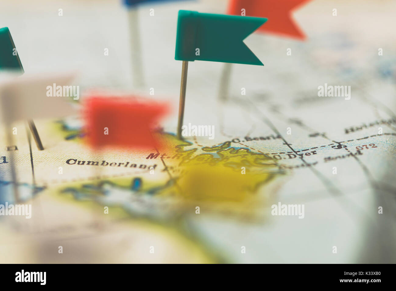 Flag shaped push pin in a vintage travel map. travel destination ...