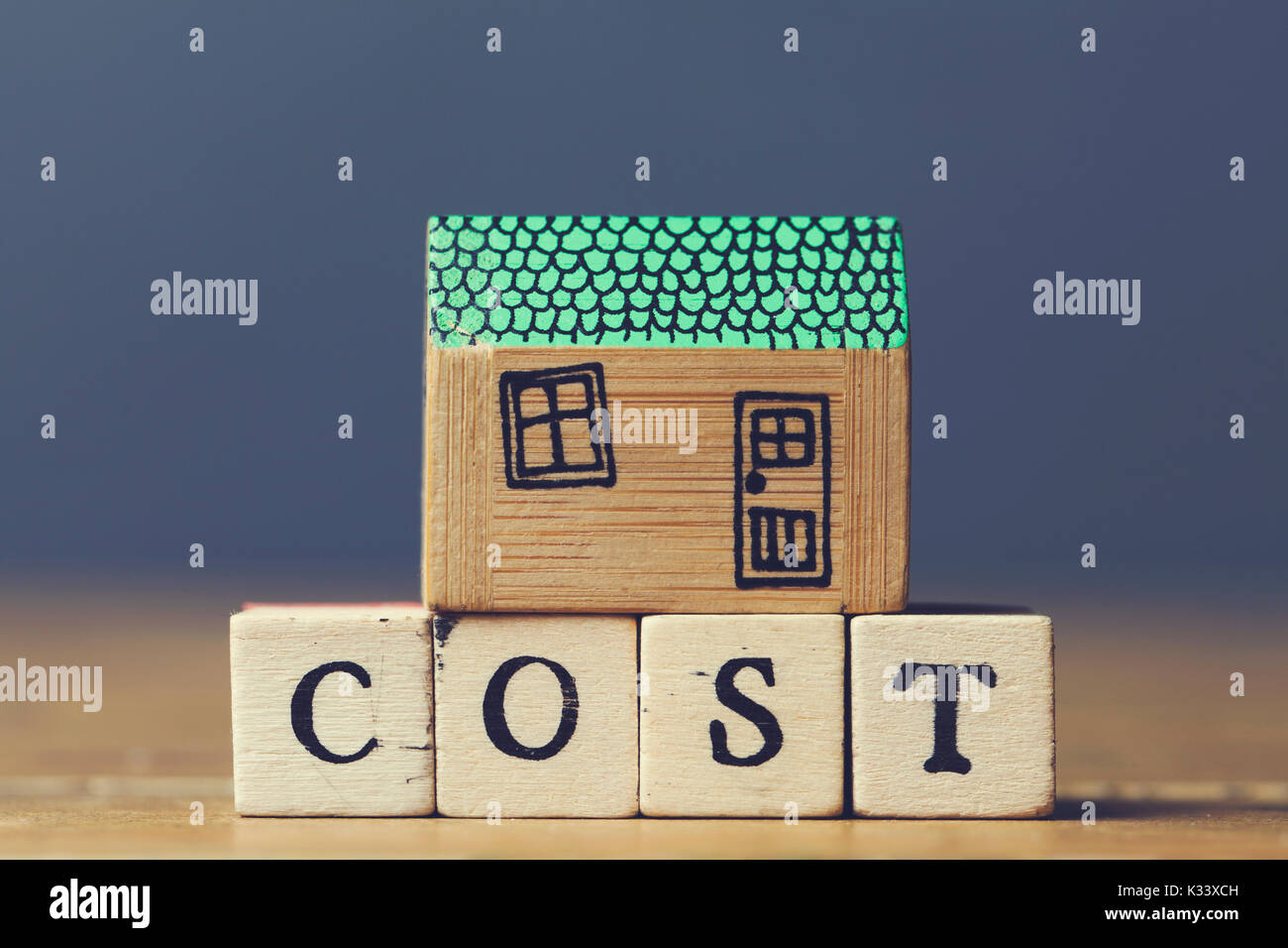 House model with cost word made from wooden blocks. Home finance ...