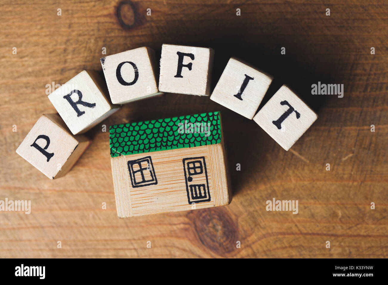 House model with profit word made from wooden blocks. Home finance ...