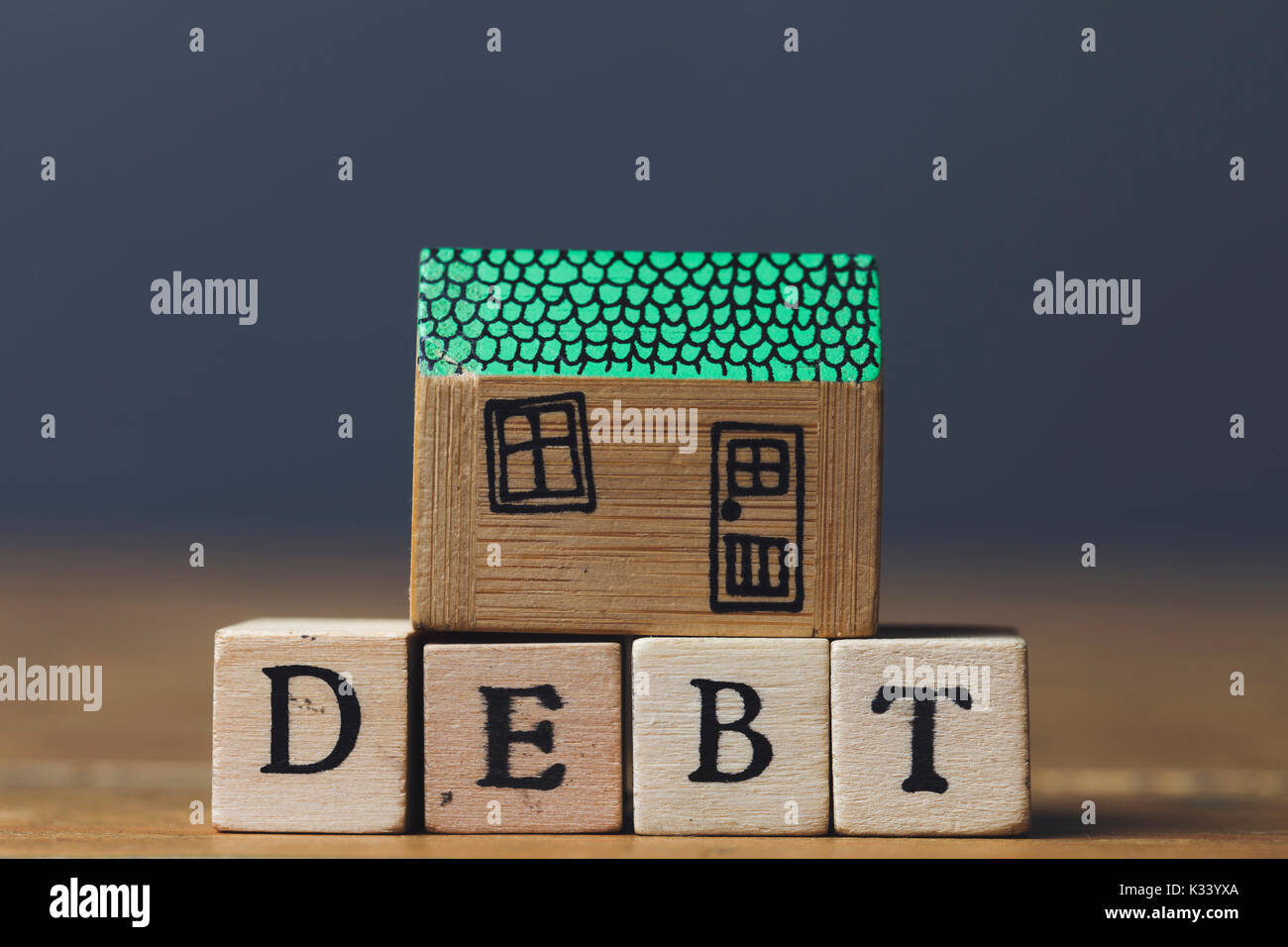 Home debt concept. House model with debt word made from wooden blocks ...
