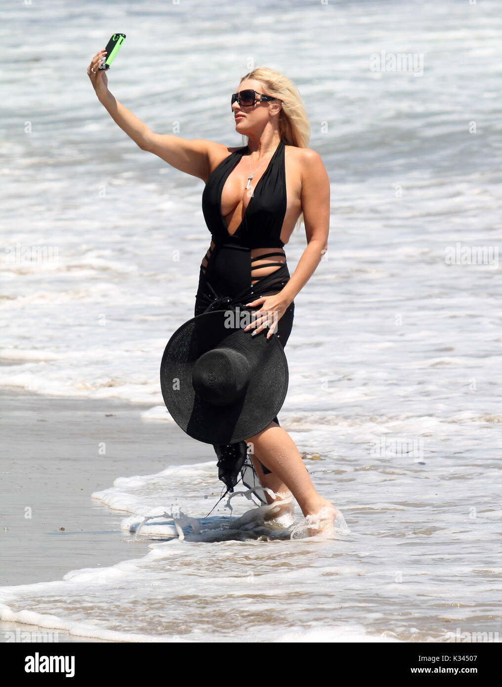 Australian burlesque magician Suzie Malone tries to take the perfect selfie on Malibu Beach ...
