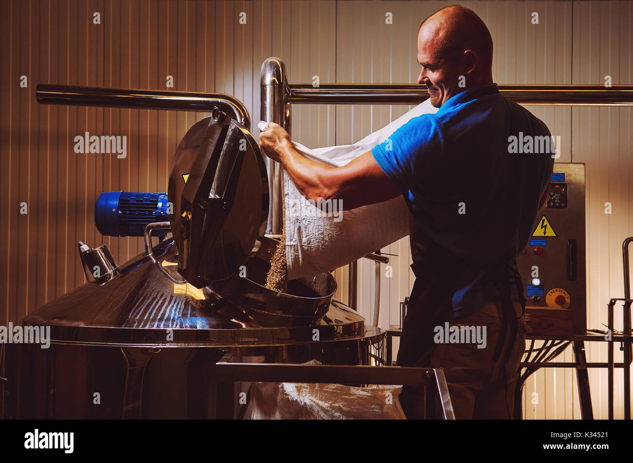 Brewer in brewhouse pouring out the malt to the tank Stock Photo - Alamy