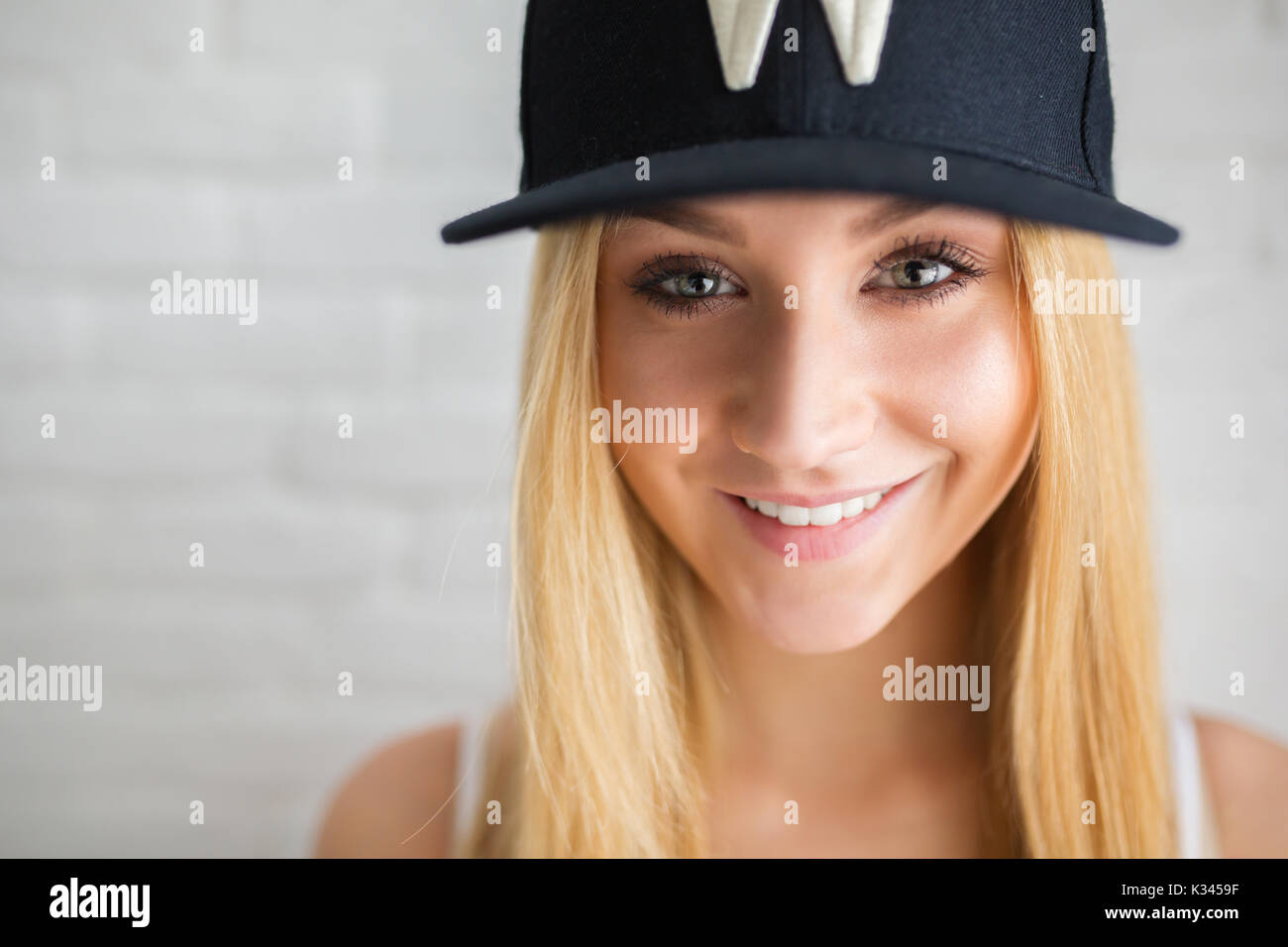 A photo of young, beautiful woman wearing black cap. She's smiling ...
