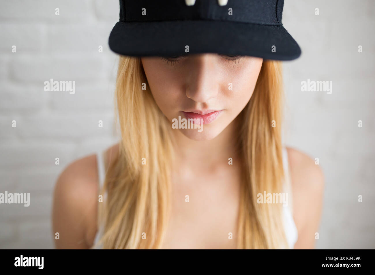 A photo of young woman wearing black cap which covers her eyes Stock ...