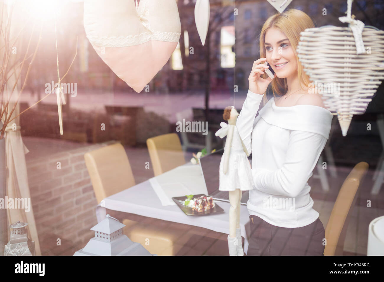 A photo of young, beautiful woman standing next to the window at some ...