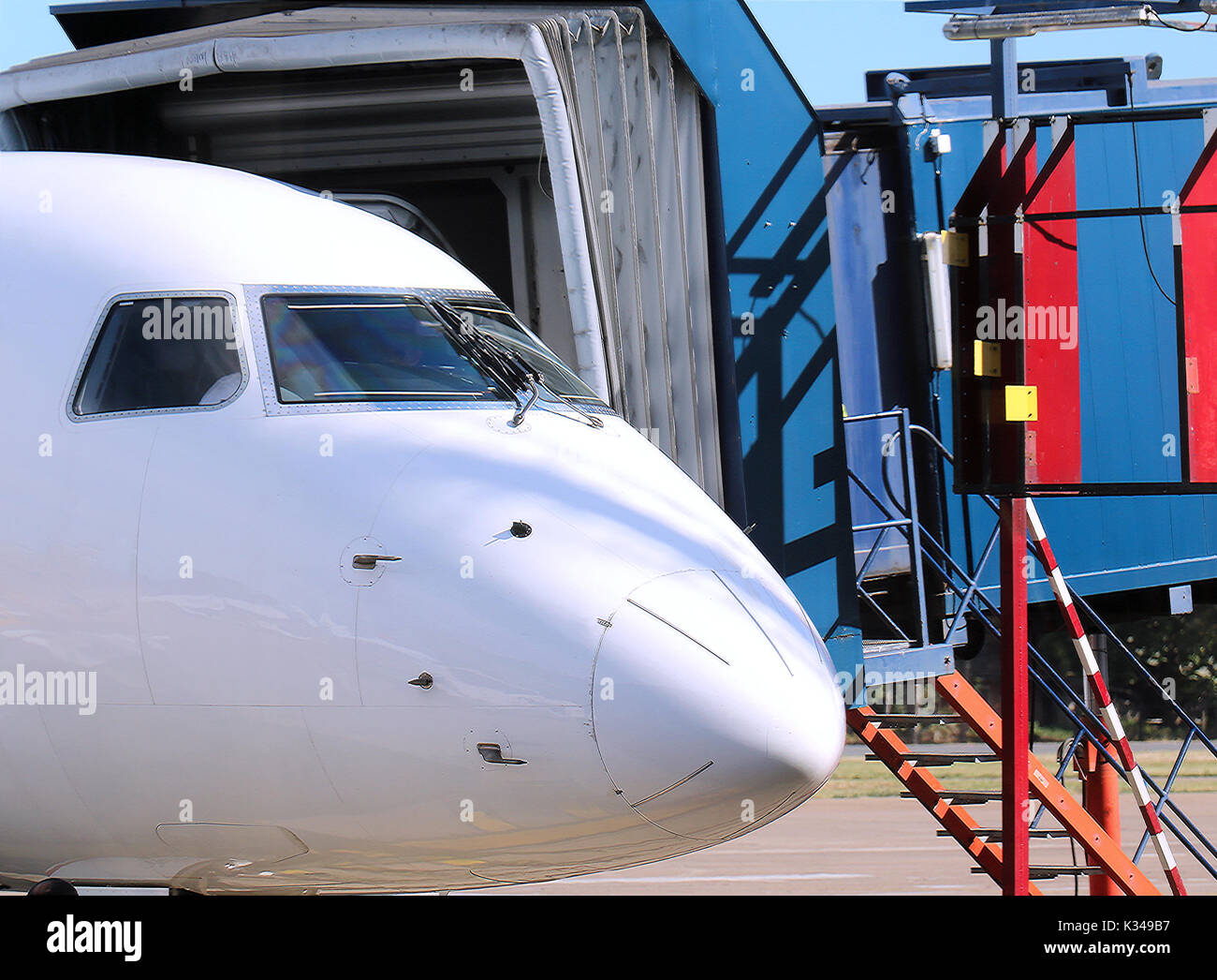Airplane next to bridge entrance on airport Stock Photo - Alamy