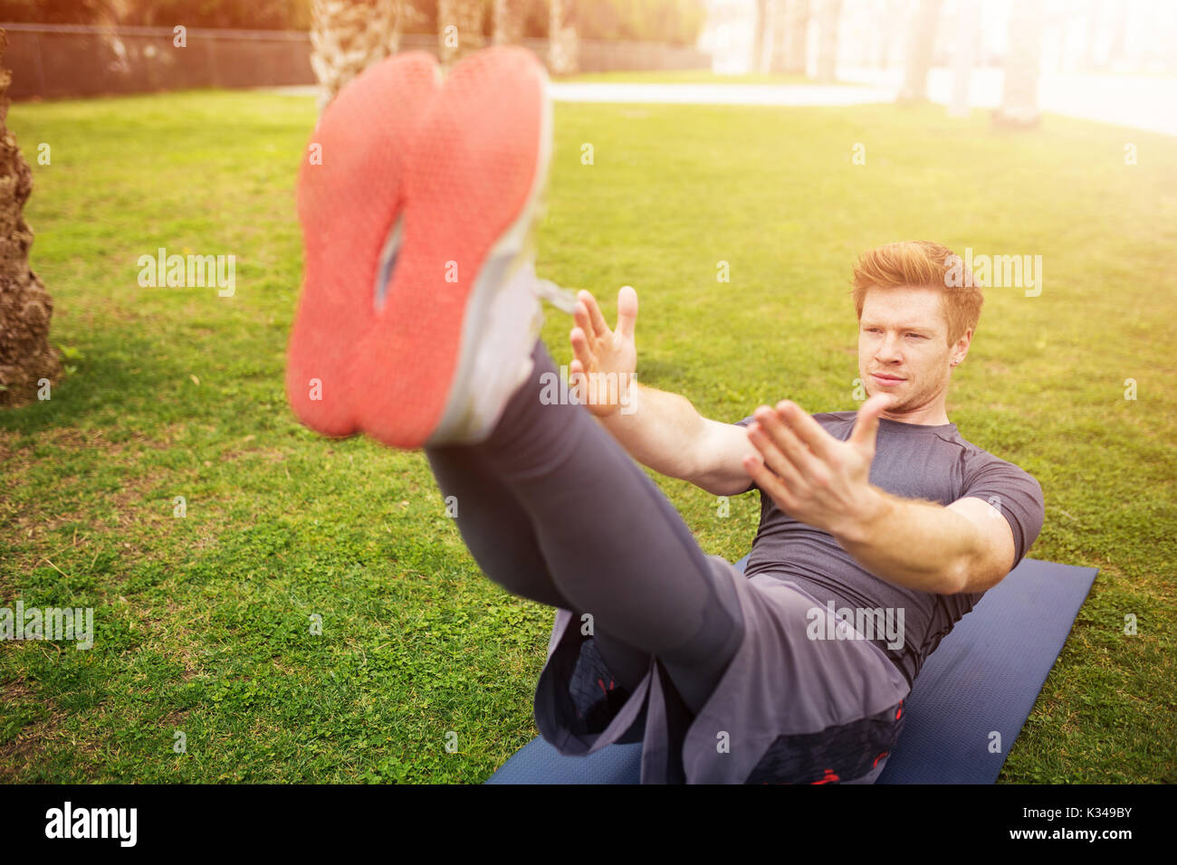 A photo of young, sporty man doing some relaxation exercises on the gym ...