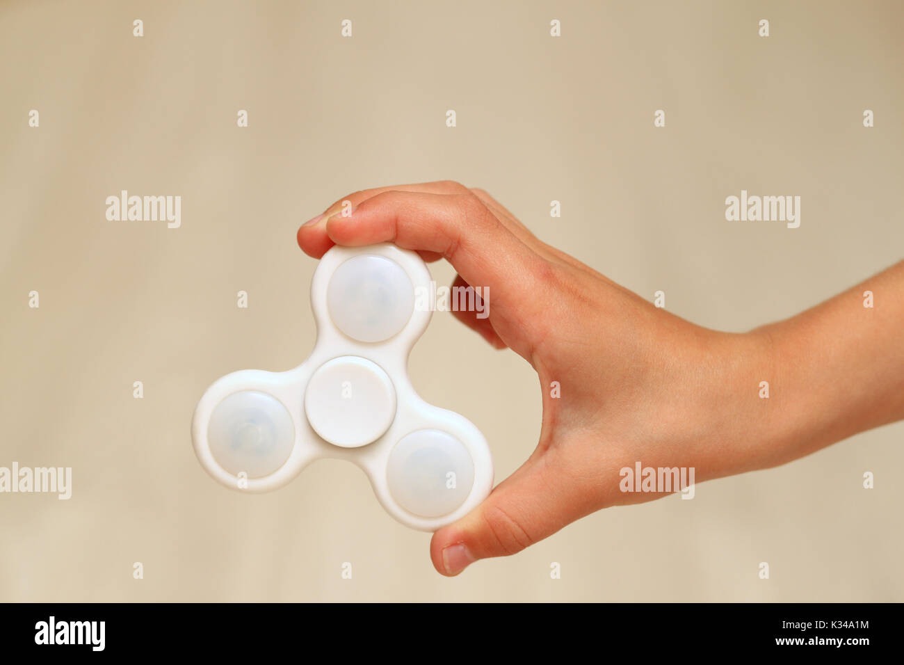 White fidget spinner toy in hand of a child Stock Photo - Alamy
