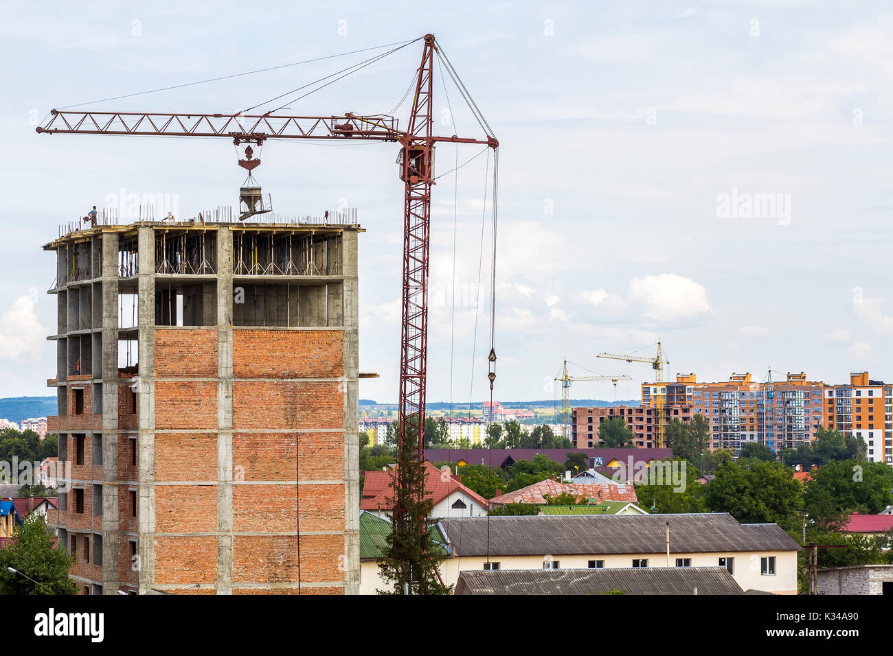 High storey building under construction with tower crane and workers ...
