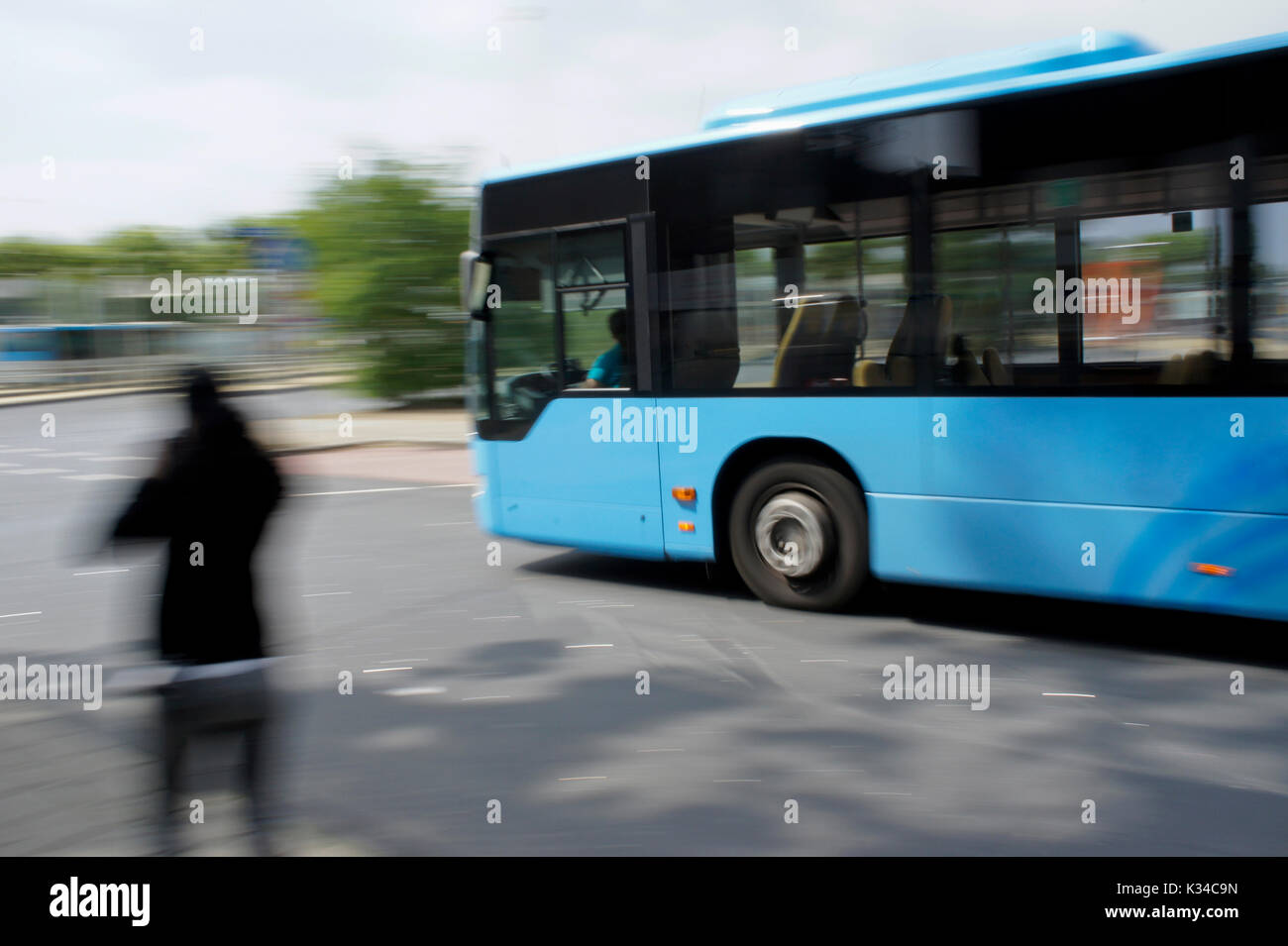Blue bus driving by Stock Photo - Alamy