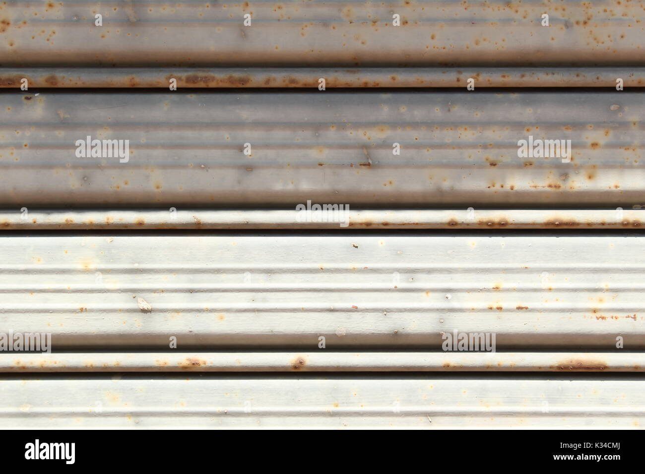 Rusty metal shutter, half shadowed. Closeup Stock Photo - Alamy