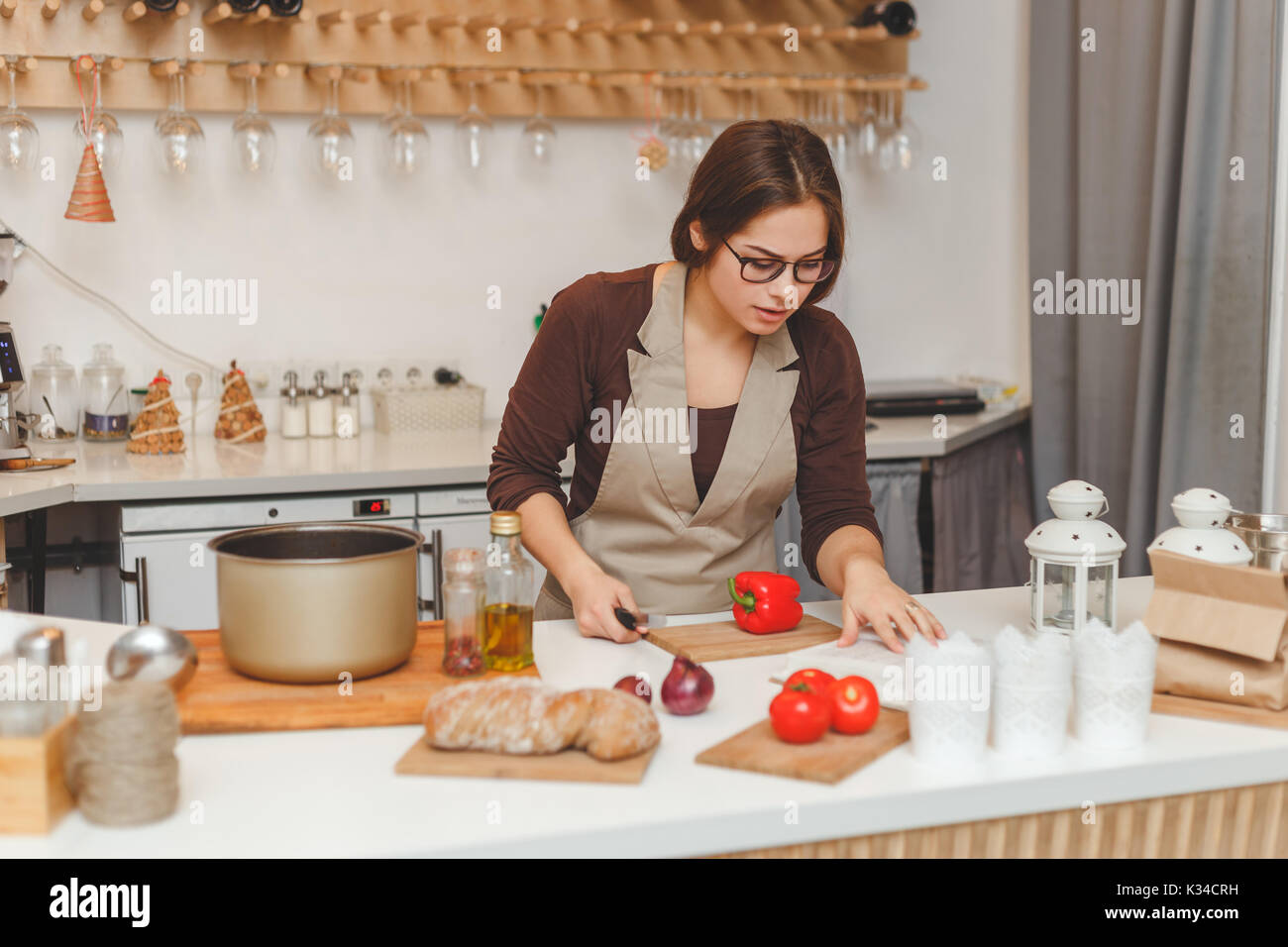Young woman reading a recipe from the book Stock Photo - Alamy