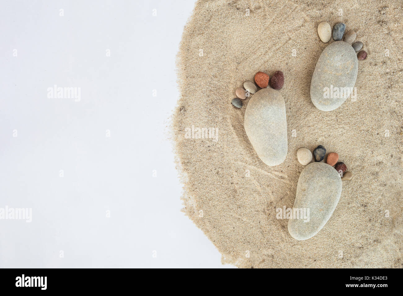 Group of pebble stones on sand creating de form of a foot in isolated ...