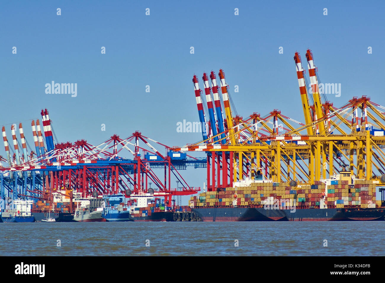 Colorful port facilities with cranes, containers and freight ships ...