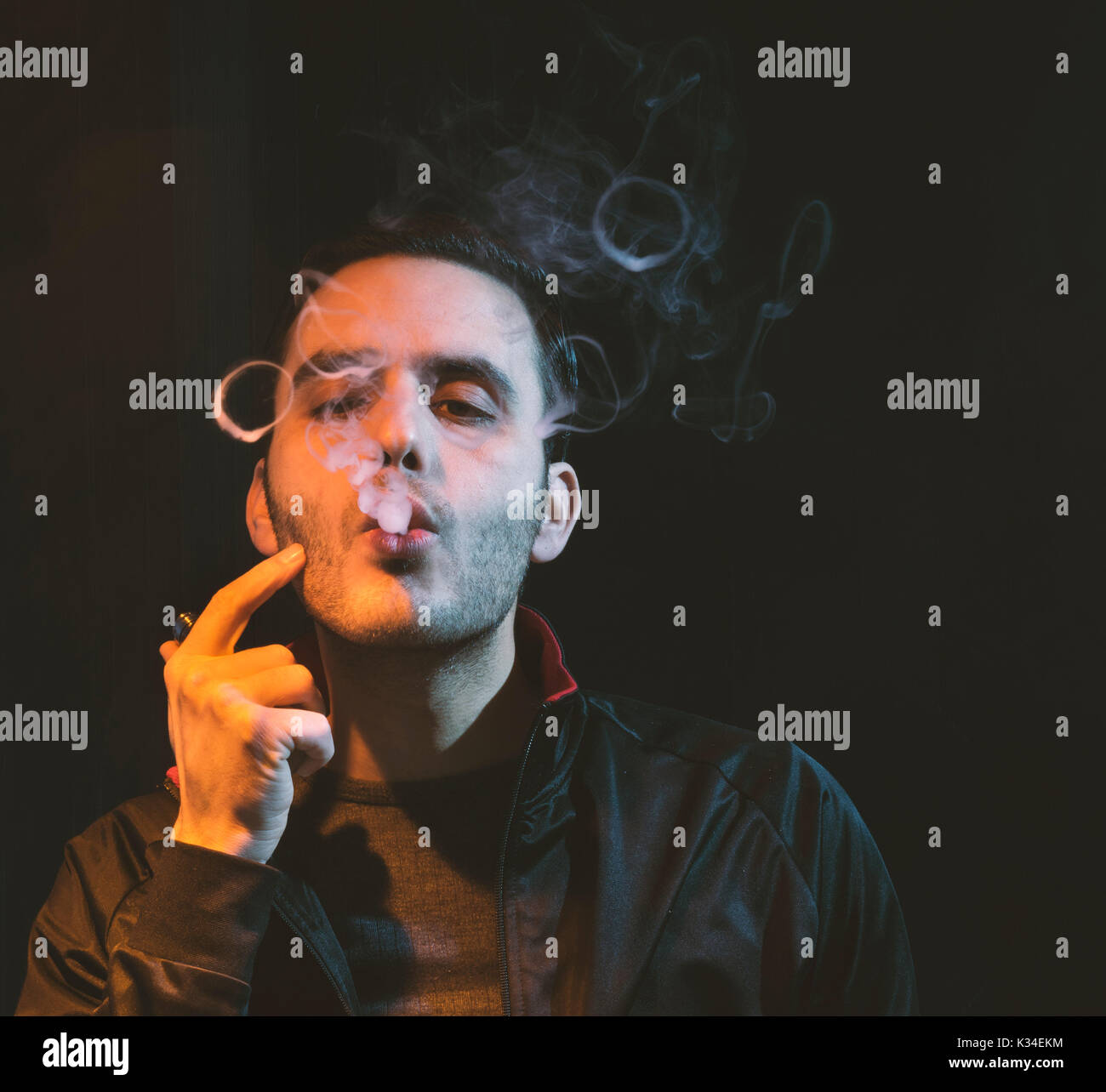 Isolated young man on a black background holding an electronic ...