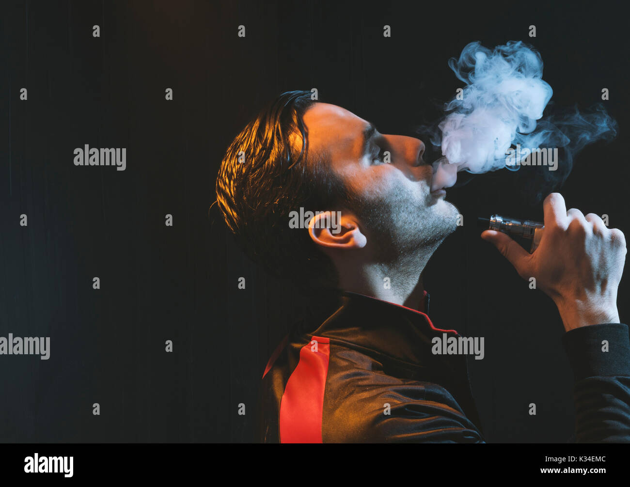 Young man holding vaping device hi-res stock photography and images - Alamy