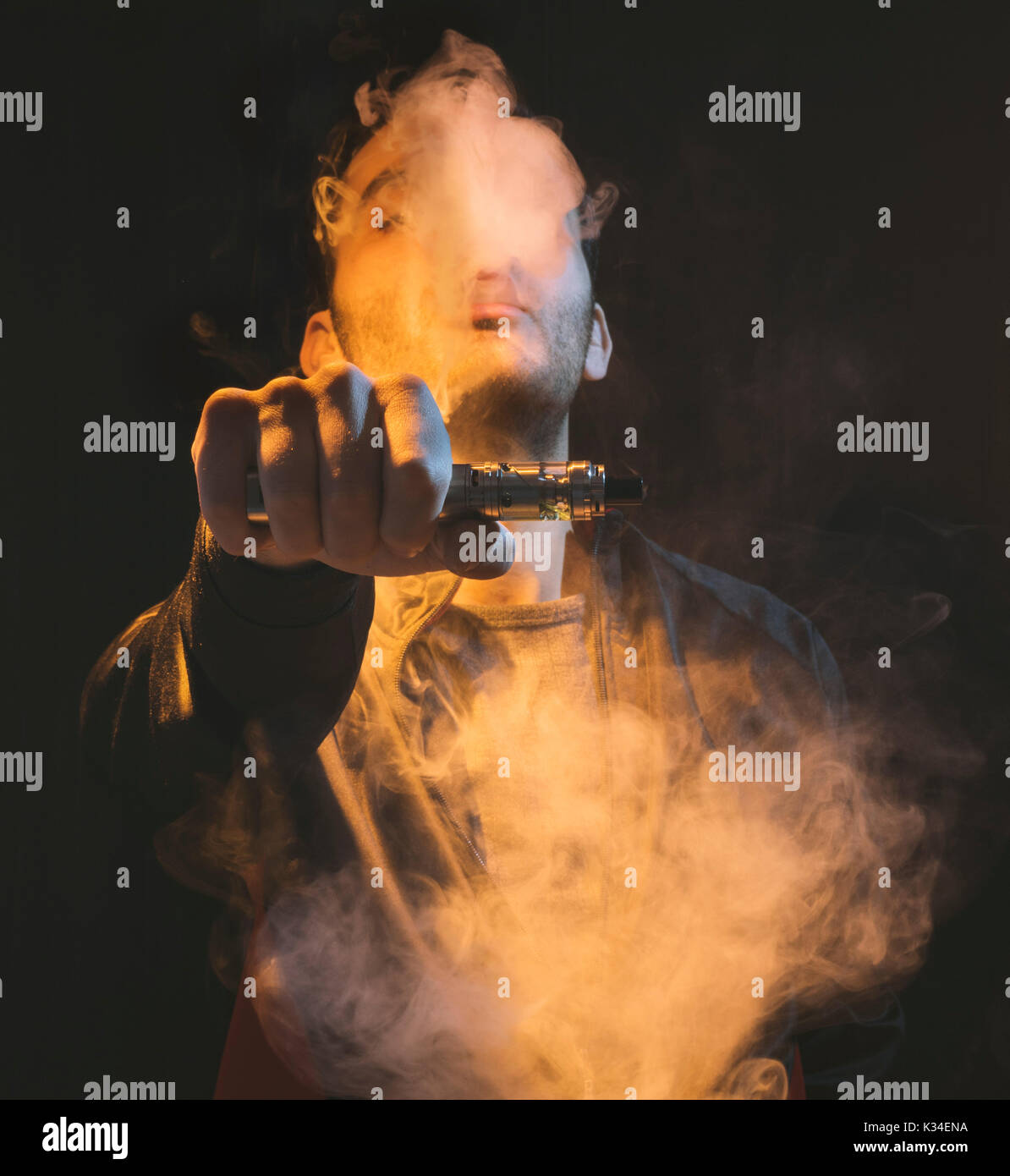 Isolated young man on a black background holding an electronic ...