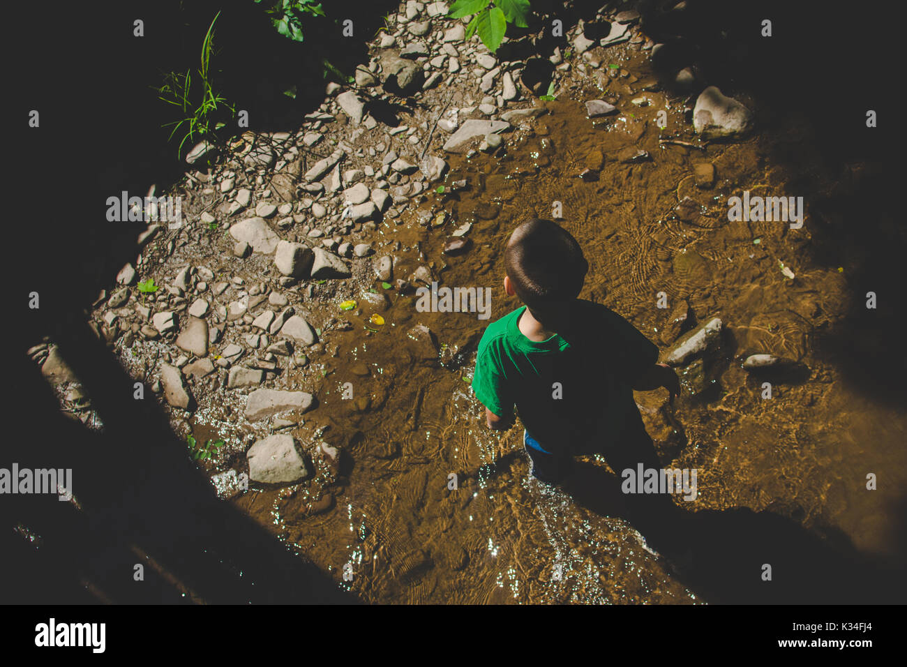 A boy walks in a stream Stock Photo - Alamy