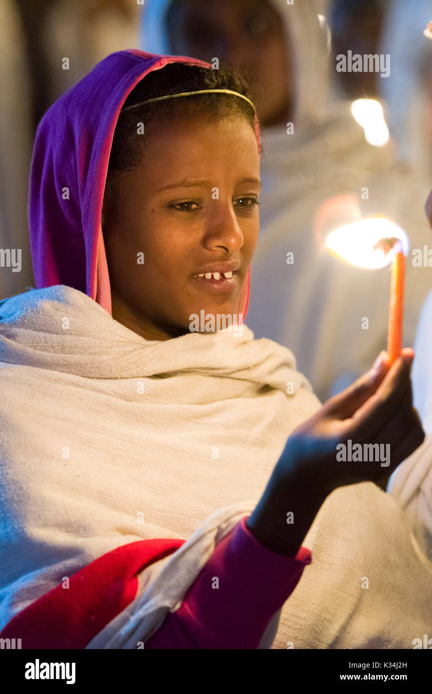 Young female pilgrim holding a candle to signify the resurrection, in ...