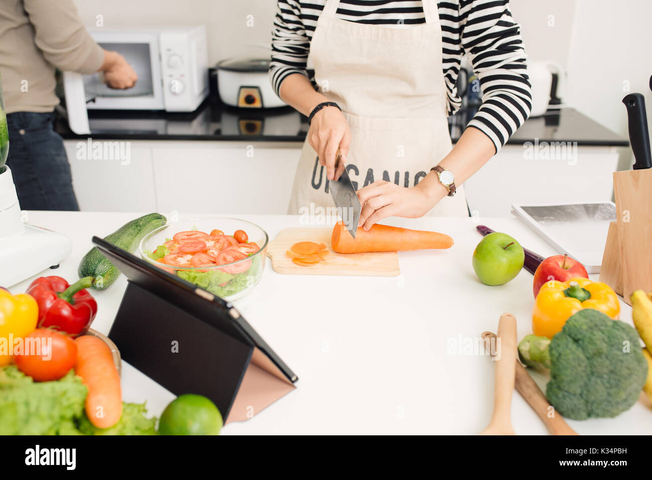 Young woman cutting vegetables in the kitchen Stock Photo - Alamy