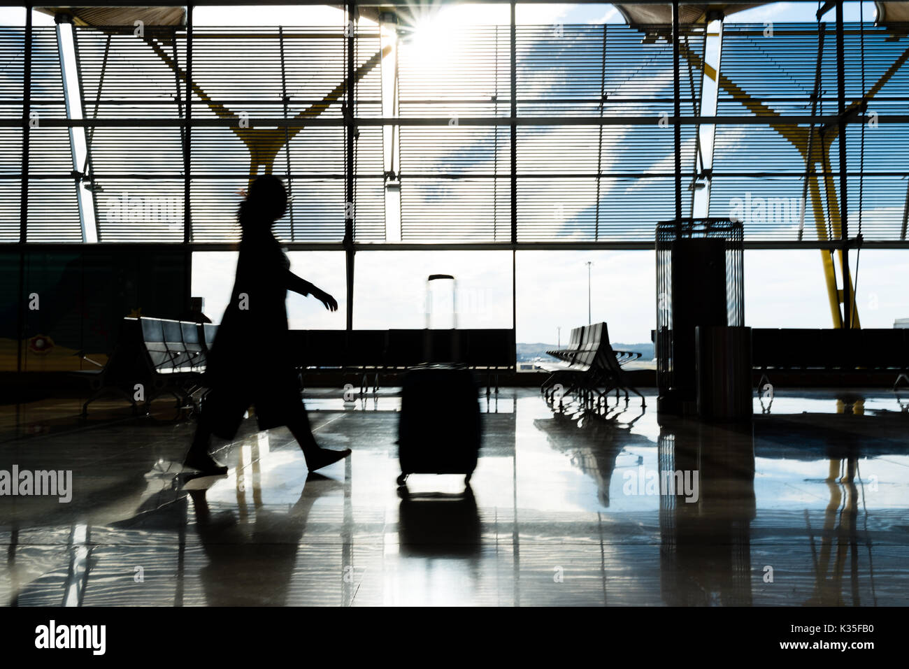 Shadow of a Woman moving with her Luggage Stock Photo - Alamy
