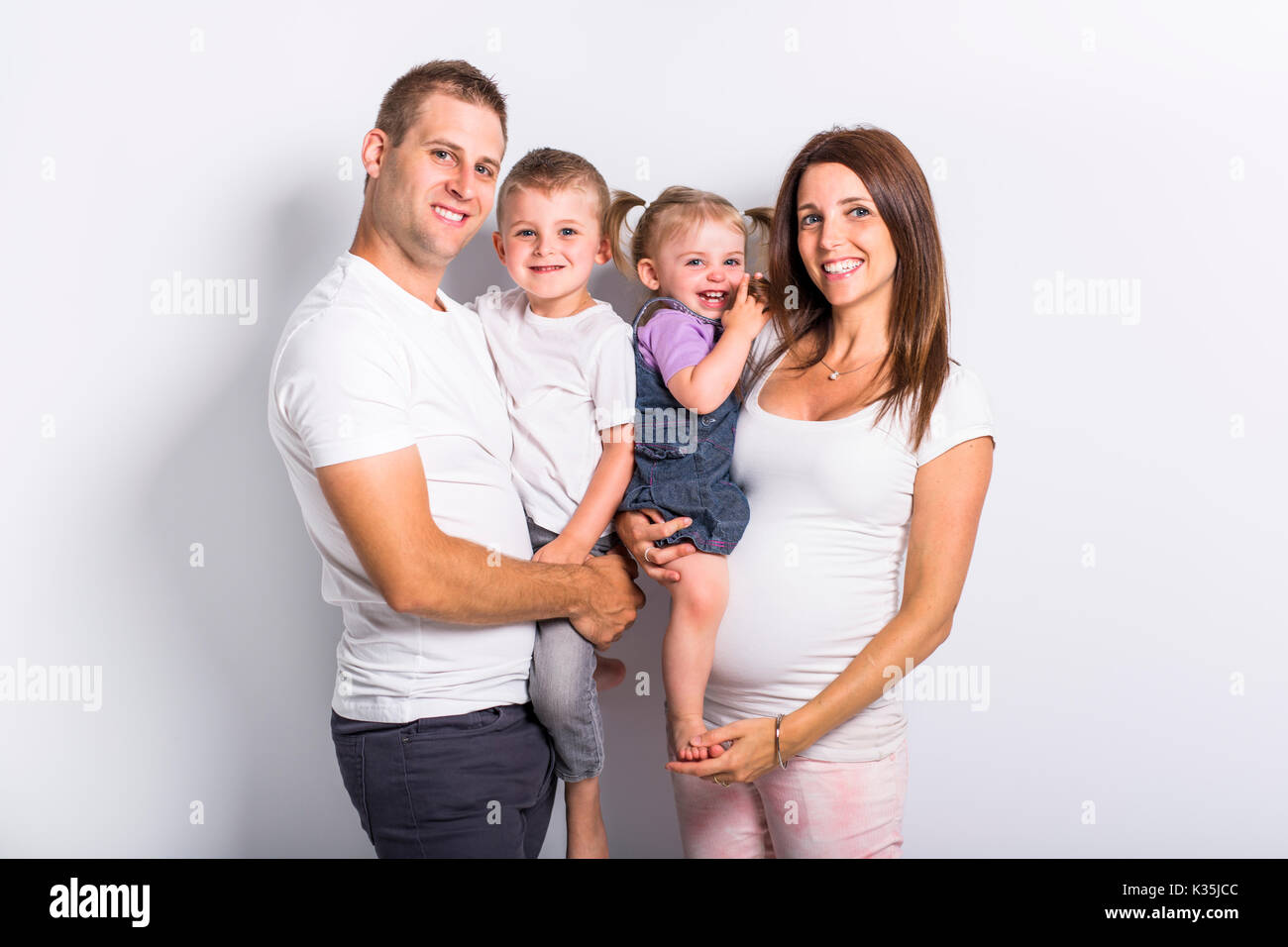 A Happy family with two kids on studio white Stock Photo - Alamy